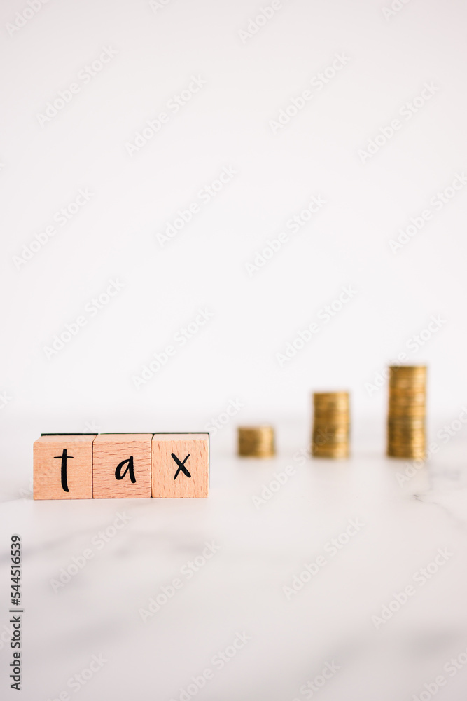 Tax text on top of growing stacks of coins, increasing tax rates and ...