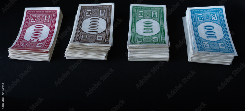 Stack of fake banknotes on black background. Stock Photo | Adobe Stock