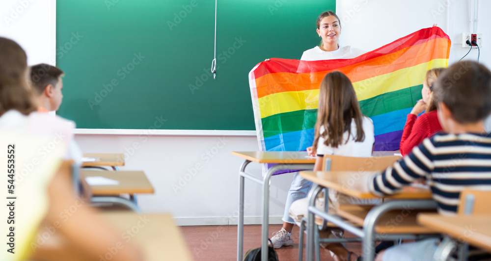 Teacher explaining meaning of LGBT flag to kids in classroom during ...