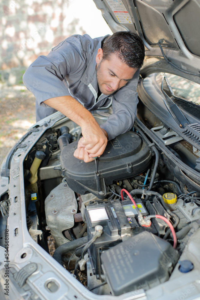 Man fixing a car engine Stock Photo | Adobe Stock