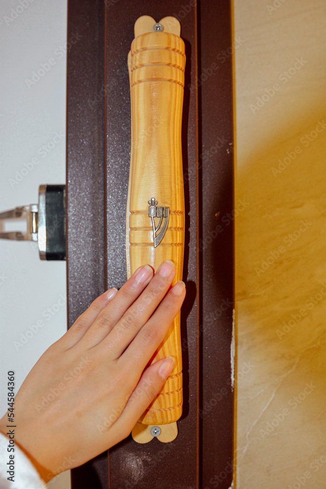 Mezuzah Jewish hand touching a mesusah on a door-post known as a klaf ...