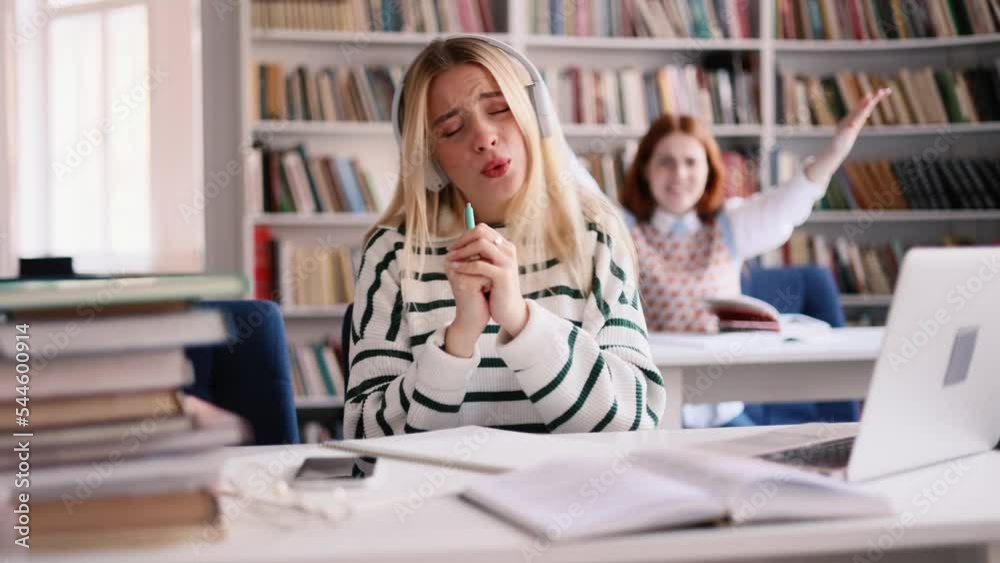 Funny happy student in headphones listening music, sing in pencil ...