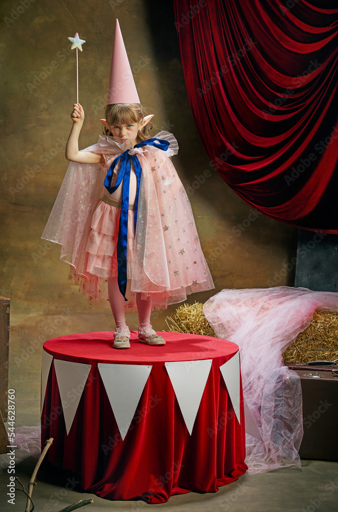 Magic. Little cute girl, kid in image of magical elf posing over dark ...