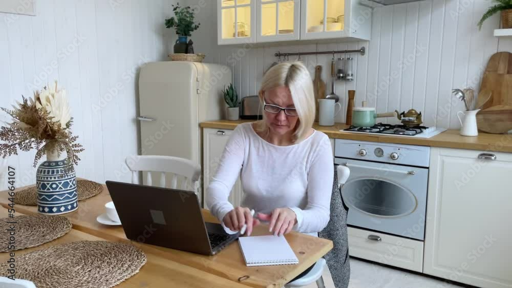 Middle-aged woman works from home. Remote education or distance employment. A 50 year old blonde ...