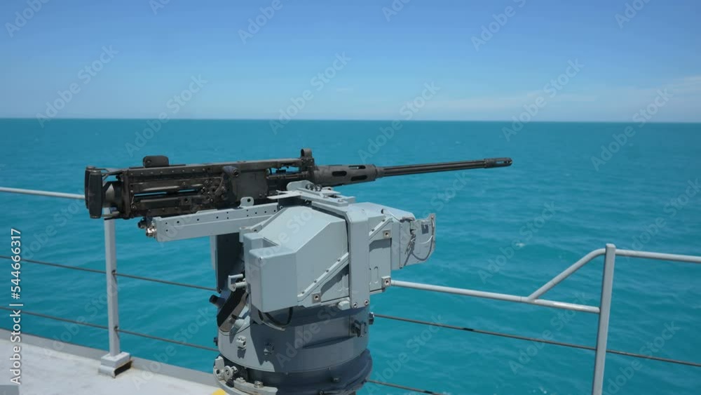 Color image of an automated machine gun on the deck of a military ship ...