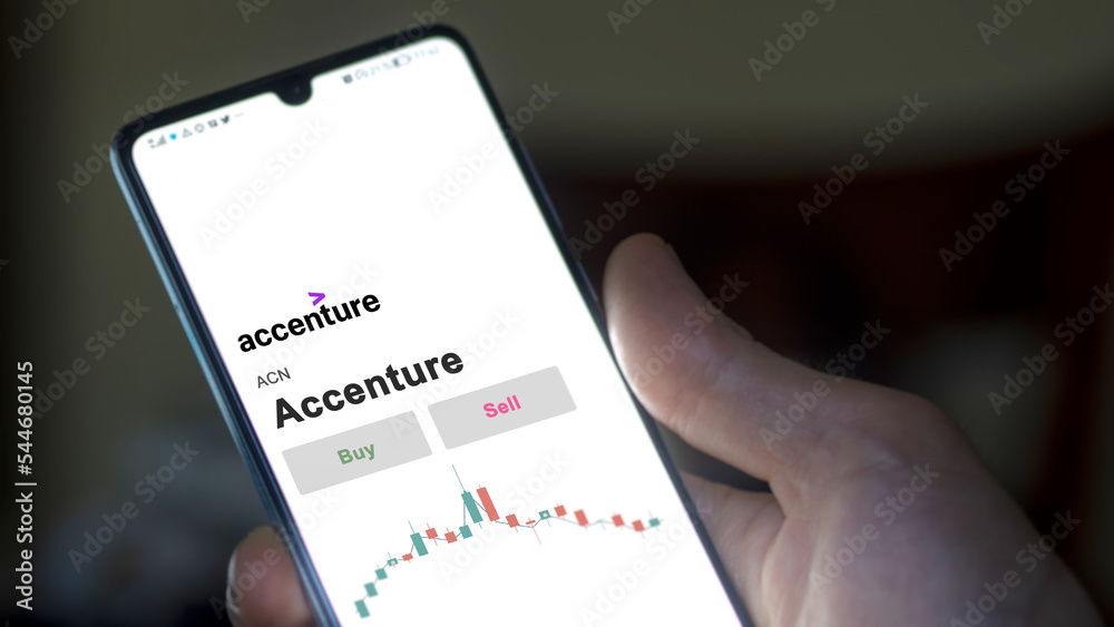 An investor's analyzing the Accenture ACN stock on screen. A phone ...