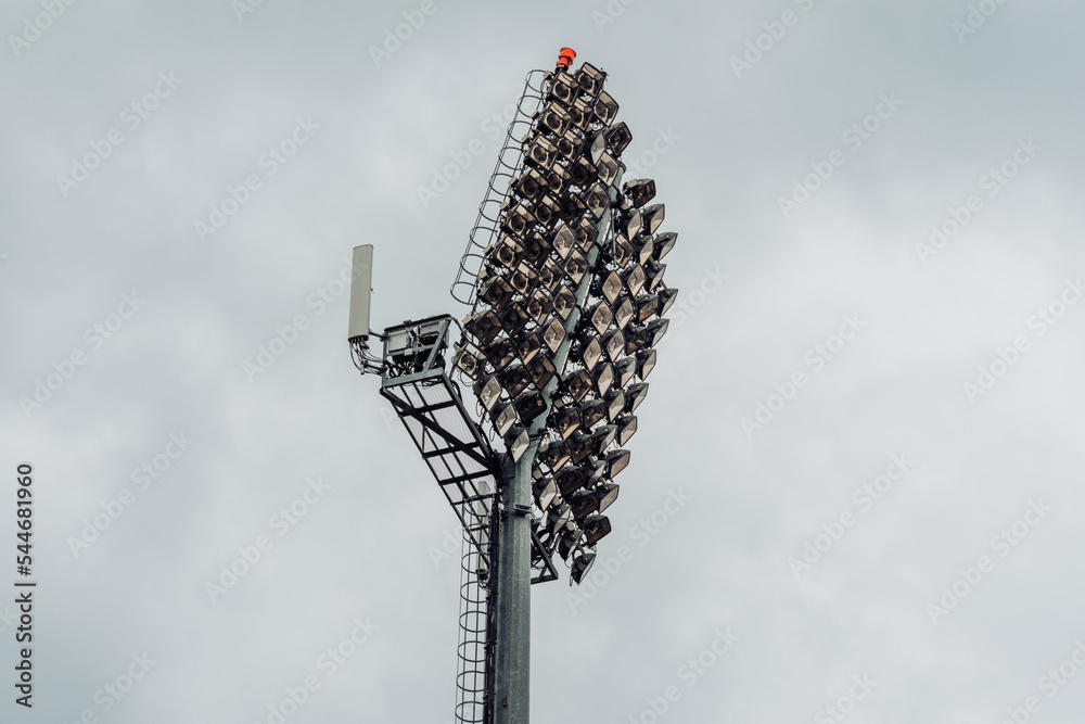 Stadium lights made of halogen bulbs in array on a concrete tower ...