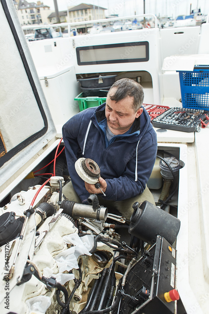 Boat mechanic repairing a ship engine Stock Photo | Adobe Stock