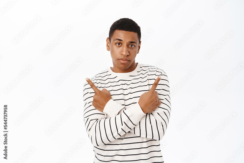 Complicated Black man pointing sideways, showing left and right way ...