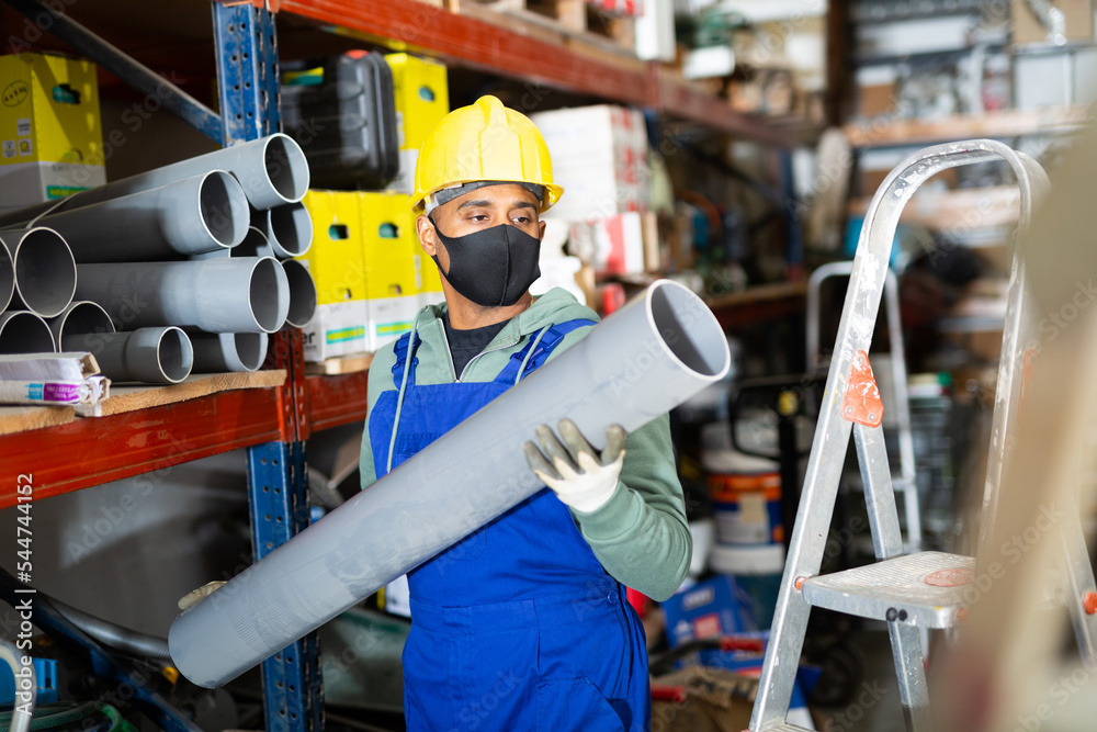 Latin american foreman wearing protective mask looking for PVC pipes ...