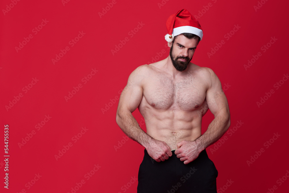 Sexy santa, young shirtless bodybuilder wearing a christmas hat ...