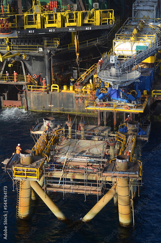 Offshore construction -workers prepare a platform jacket for a riser ...