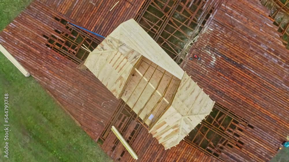 rising aerial footage of a wooden plateau and house under construction ...