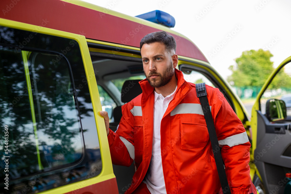Ambulance staff member emerges from the back of an ambulance with his ...