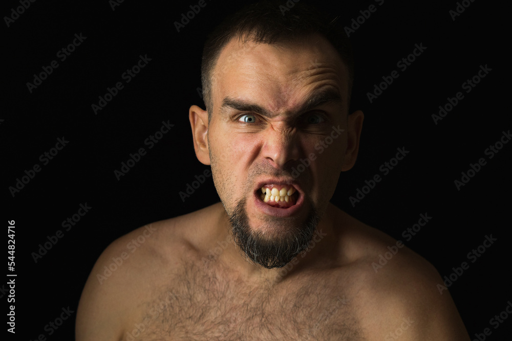 Portrait of an angry young man with open mouth and clenched teeth ...