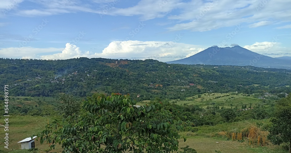 Landscape view of mountains, hills, trees and blue sky with a ...
