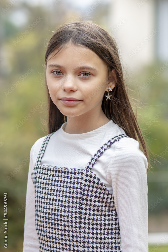 Street portrait of an 11-year-old beautiful girl with long dark hair on ...