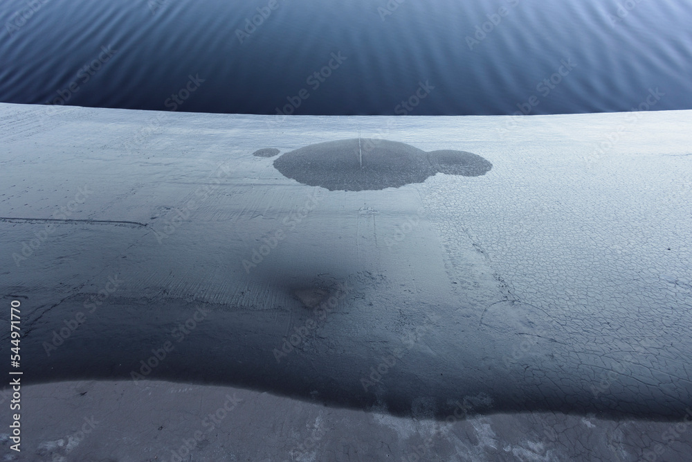 Frozen asphalt surface is covered by cold ice. Texture, structure and ...