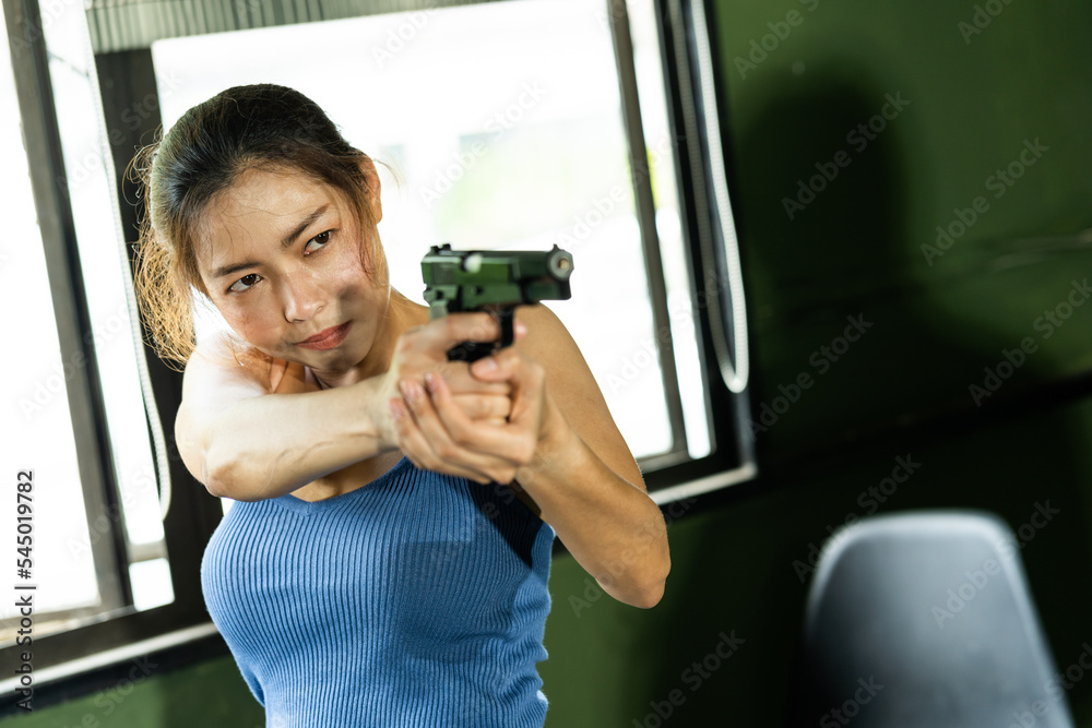 Beautiful young asian serious woman holding gun and getting ready for ...