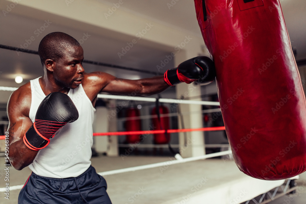 Fit African boxer practicing his punches at the gym Stock Photo | Adobe ...