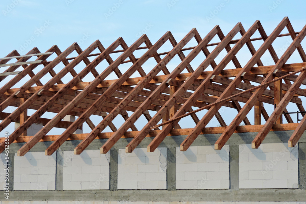 A timber roof truss in a house under construction, walls made of ...