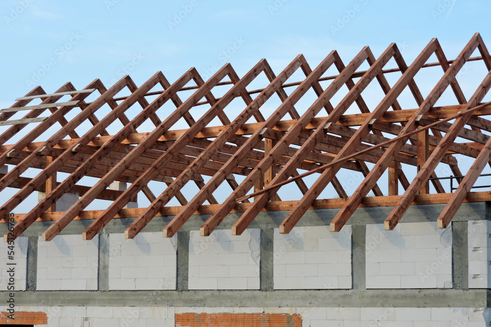A timber roof truss in a house under construction, walls made of ...