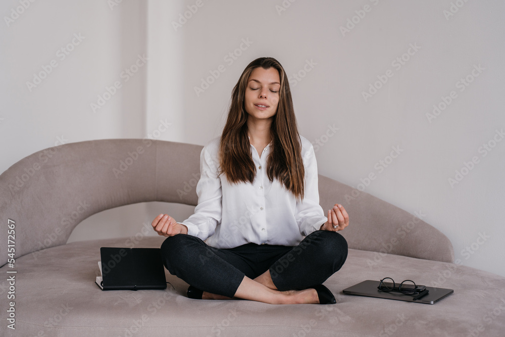 Exhausted brunette Hispanic young woman in white shirt and black pants ...