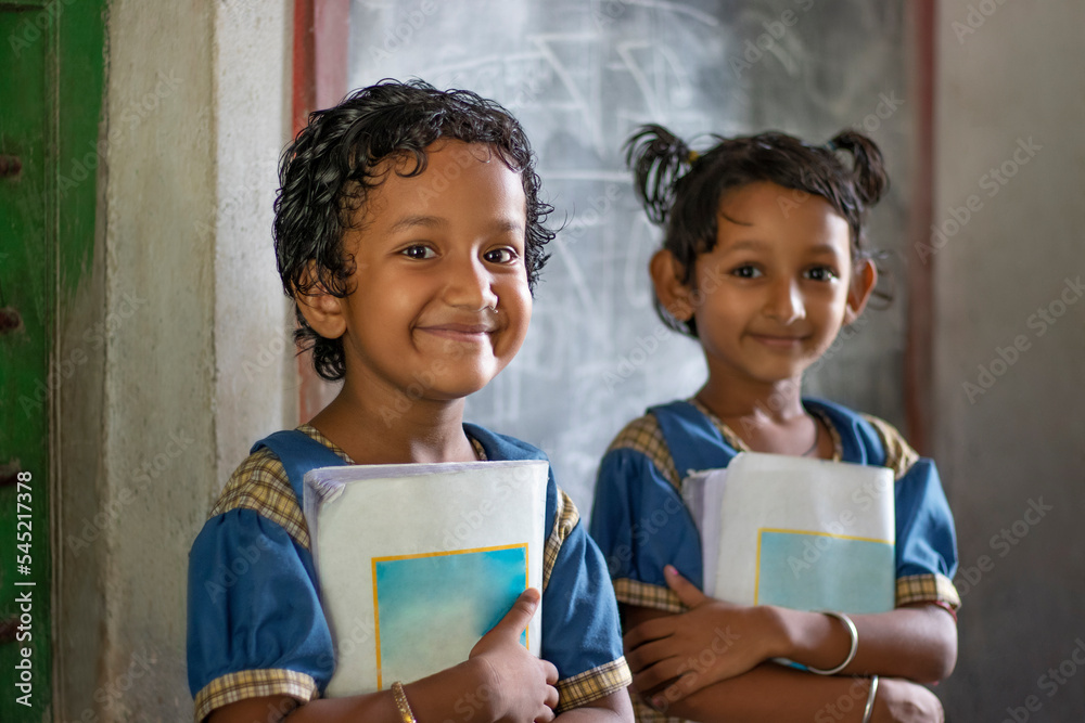 Three School Children's holding books standing at school Stock Photo ...