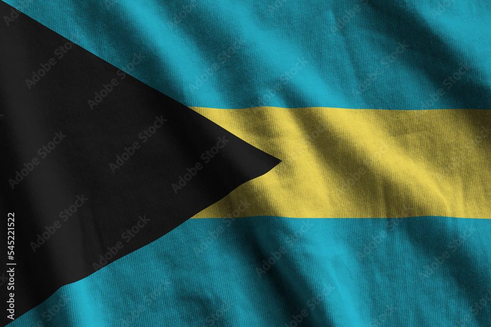 Bahamas flag with big folds waving close up under the studio light ...