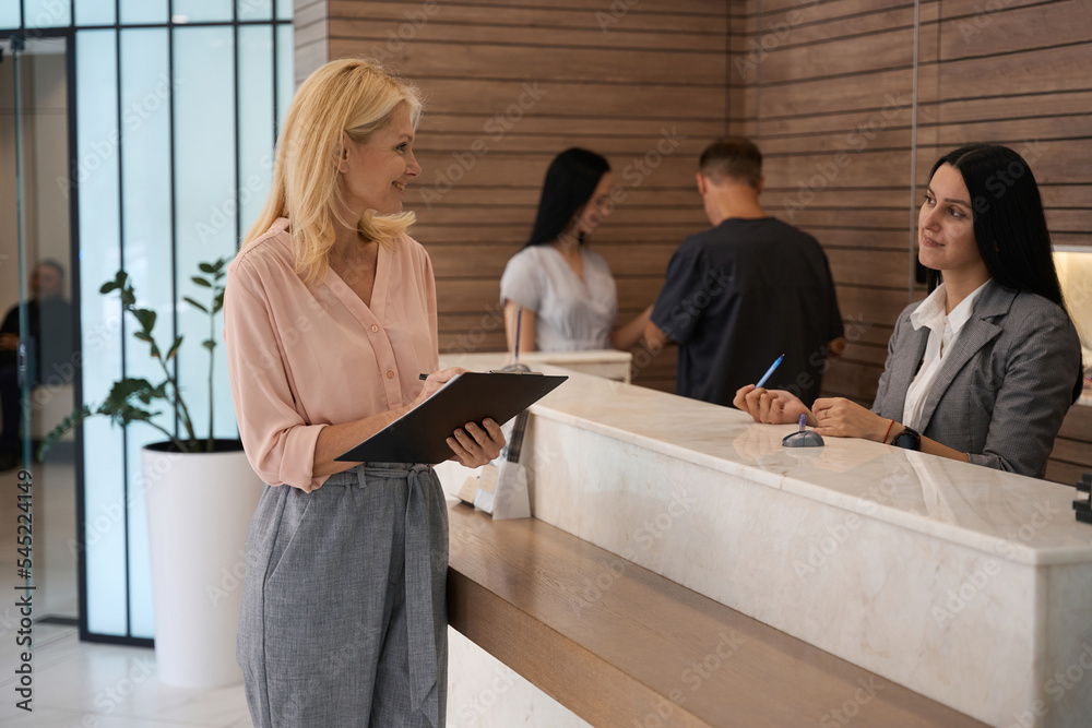 Adult woman standing by the reception zone Stock Photo | Adobe Stock