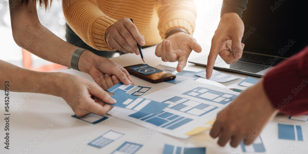 Young Asian business creative team work together, mobile application software design project ...