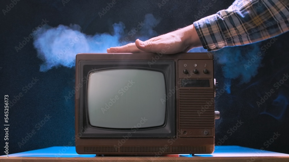 Male hand wiping dust from the surface of an old vintage TV. Retro TV ...