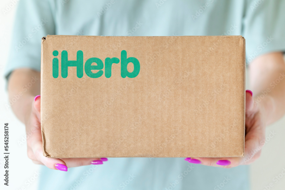 Abu Dhabi, UAE - October 15, 2021: iHerb cardboard box in woman hands ...