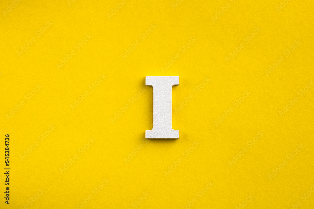 Alphabet letter I - White wood letter on yellow colored background ...