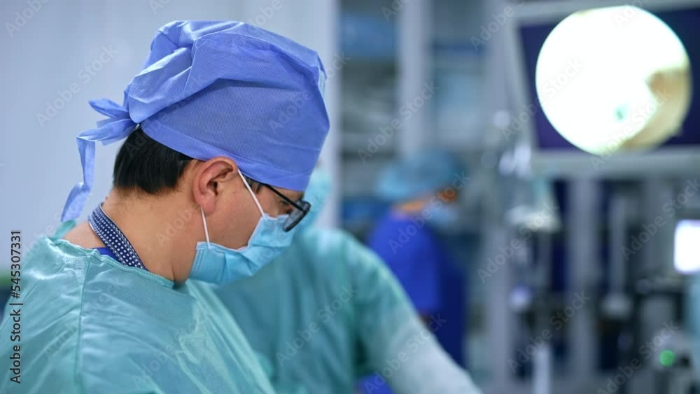 Chief surgeon looking attentively at the monitor working in the surgery ...