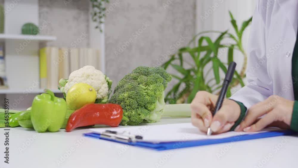 Dietitian woman taking notes and preparing meal schedule. A female ...
