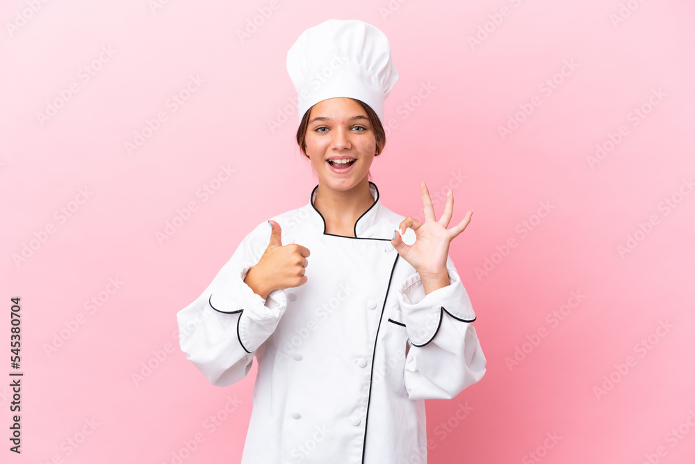 Little caucasian chef girl isolated on pink background showing ok sign ...