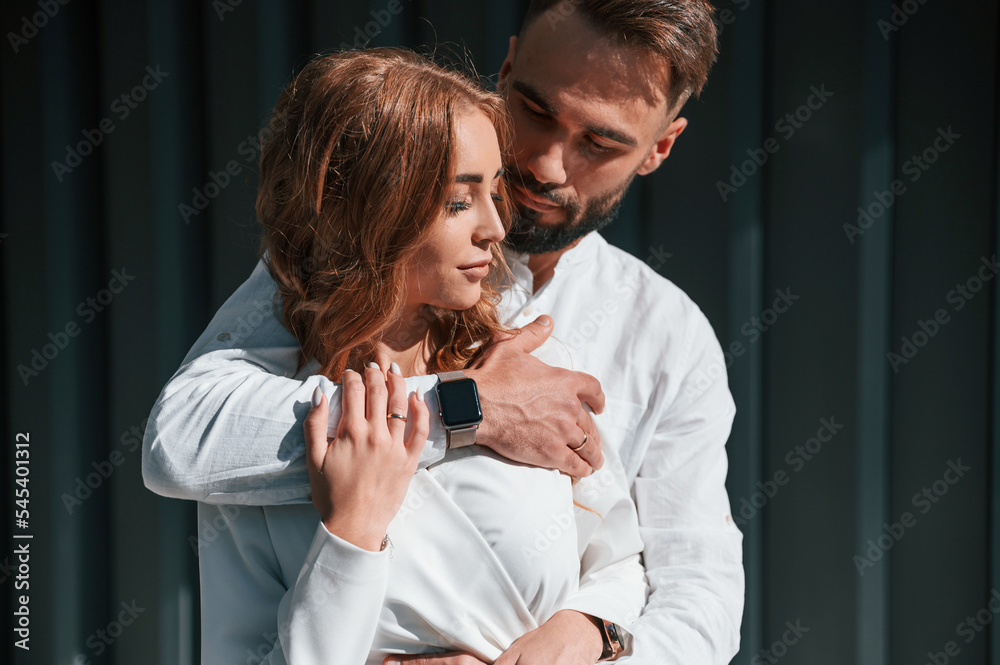 Embracing each other. Beautiful young couple is standing together ...