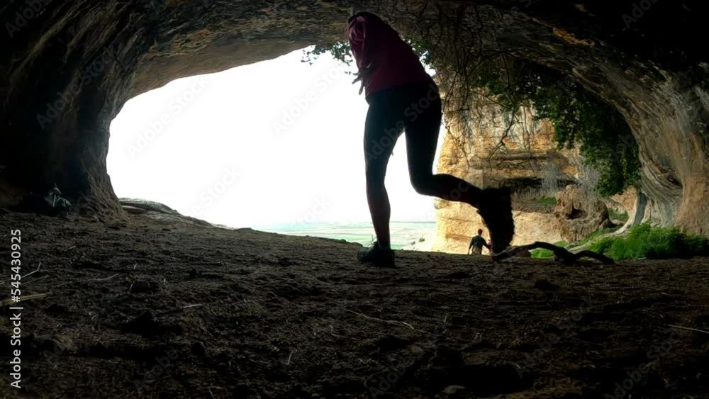 Cave exploration, exploring a cavern. Young woman explorer walks ...