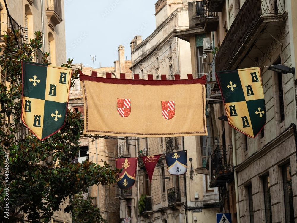 Flags of Medieval festivals hanging between buildings in Tortosa Stock ...