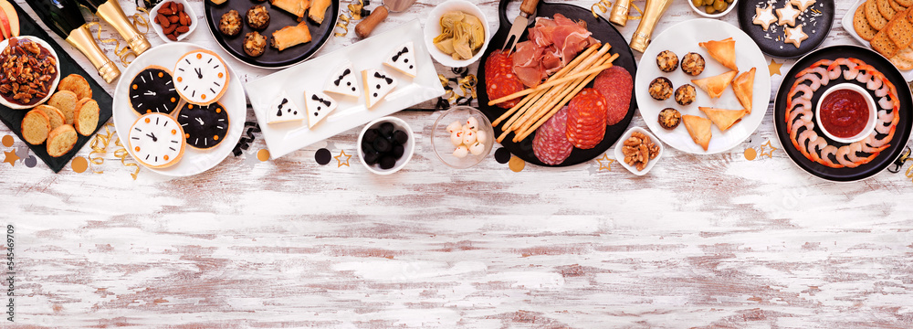 New Years Eve theme appetizer top border. Overhead view on a white wood ...