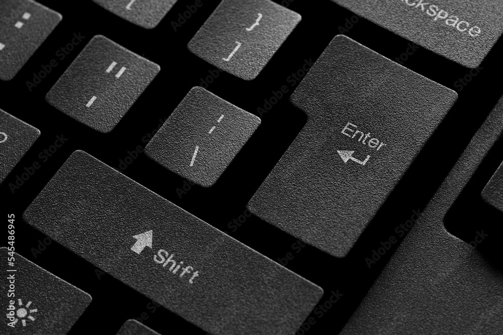 Black computer keyboard with a focus on the enter key. Confirmation ...