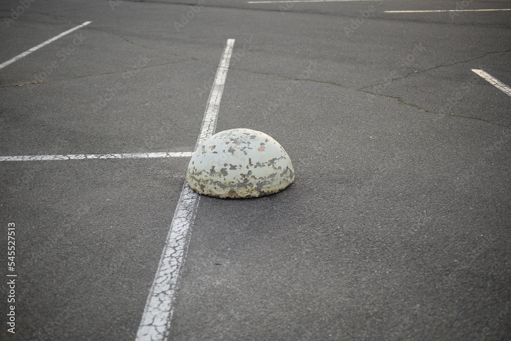 concrete traffic limiters, concrete tokens painted white, parking space ...