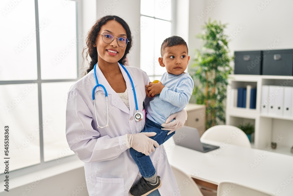 Mother and son pediatrician and patient hugging each other at clinic ...