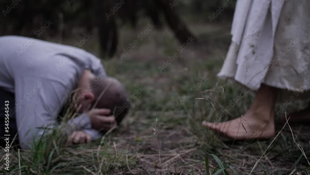 The feet of Jesus Christ walking up to a sad young man laying on the ...