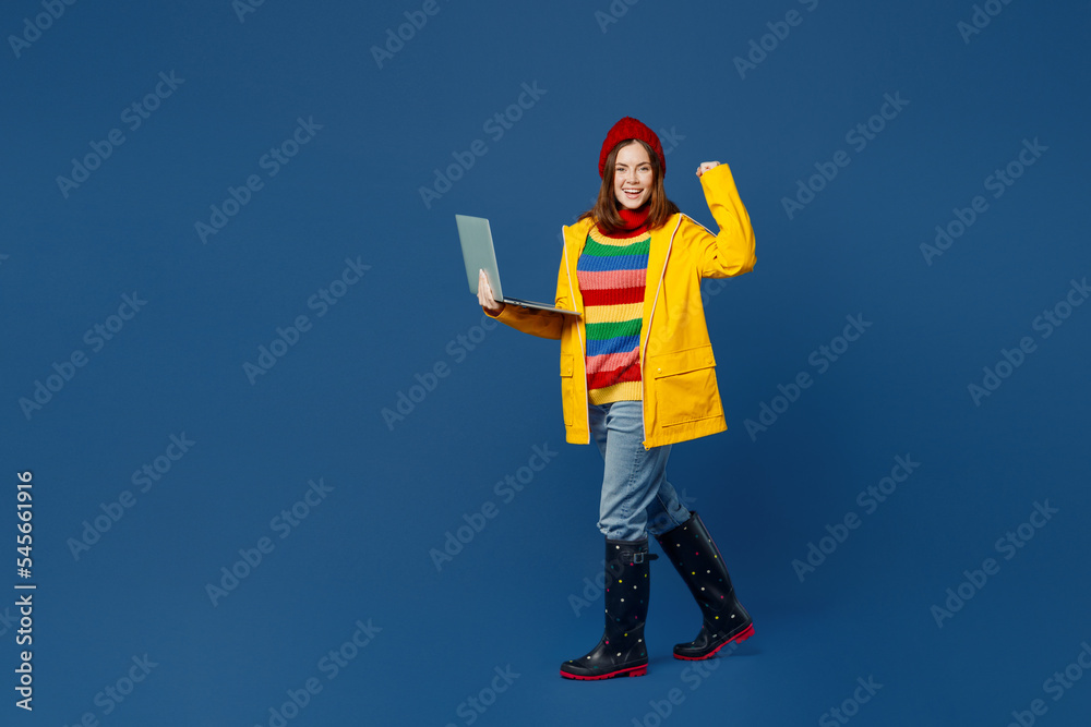 Full body young woman wear sweater red hat yellow waterproof raincoat ...