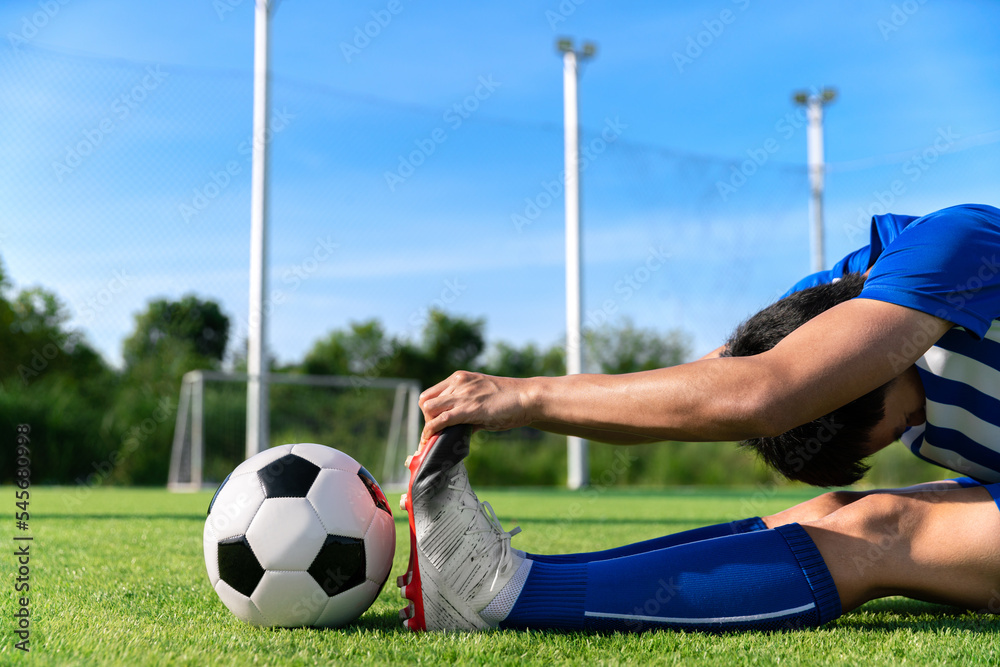 football soccer player stretching during warm up before kick ball in ...