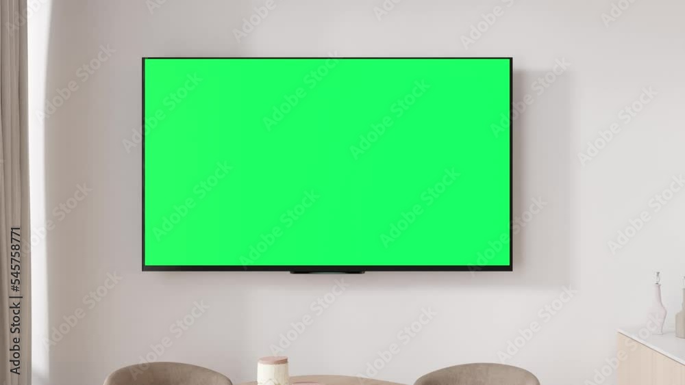 LED TV with blank green screen, hanging on the wall at home. TV video ...