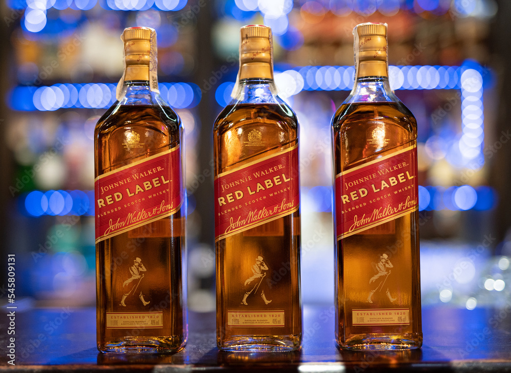 johnnie walker red label three glass bottles on the bar counter with ...