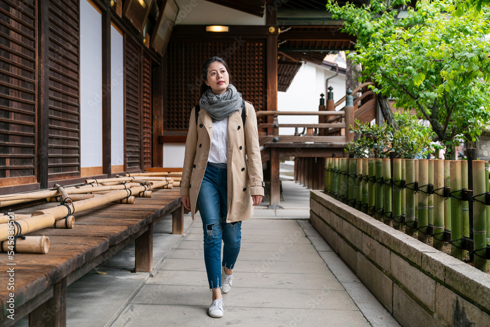 full length of Asian Japanese female backpacker admiring the view while ...